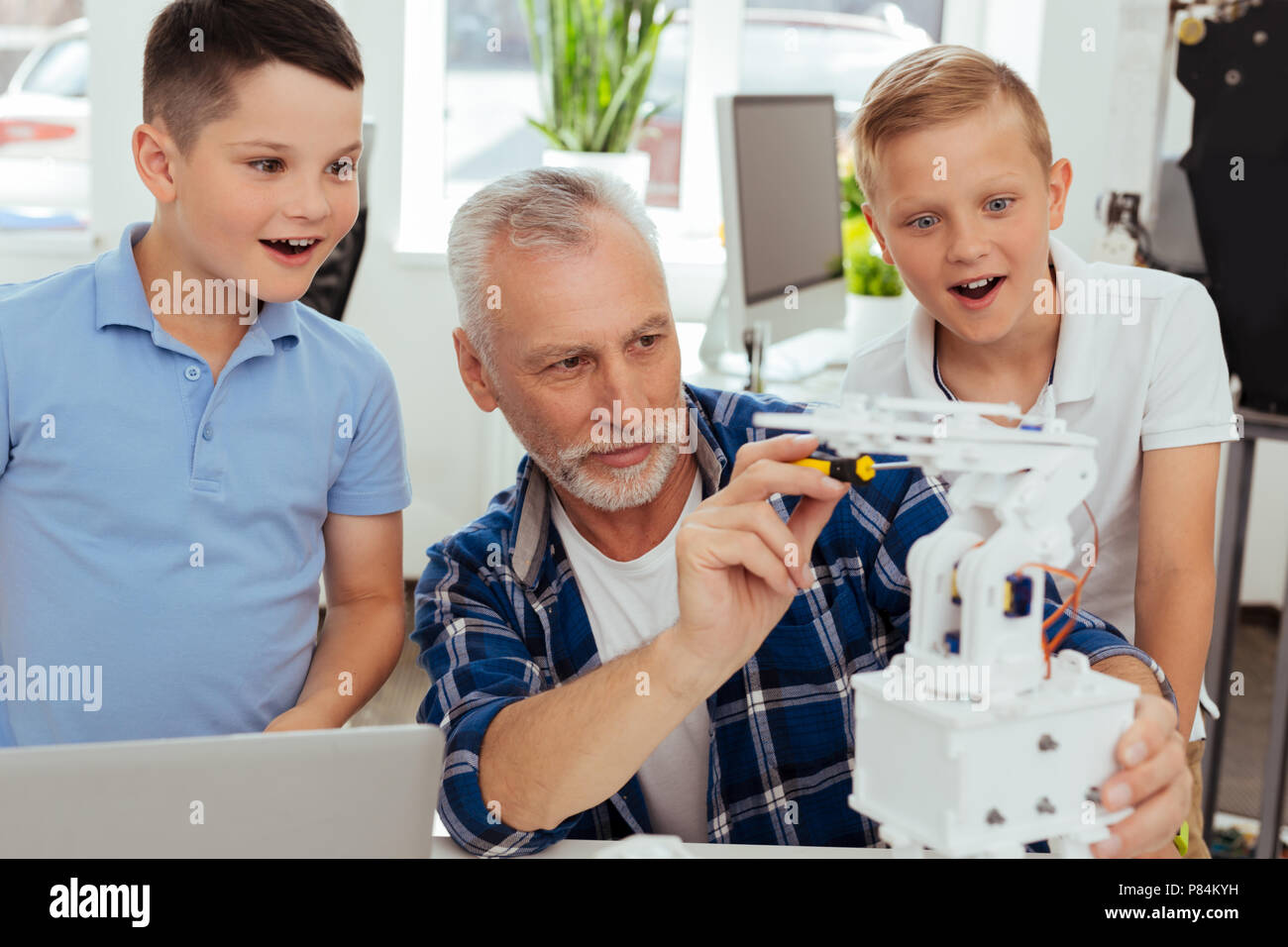 Positive excited boys standing behind their teacher Stock Photo - Alamy