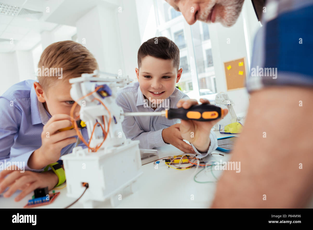 Positive cute boy making a robot Stock Photo - Alamy