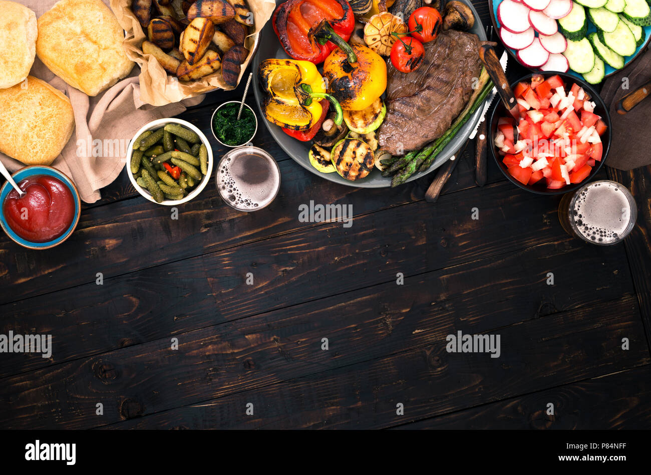 Set of different food cooked on grill on dark wooden table with border ...