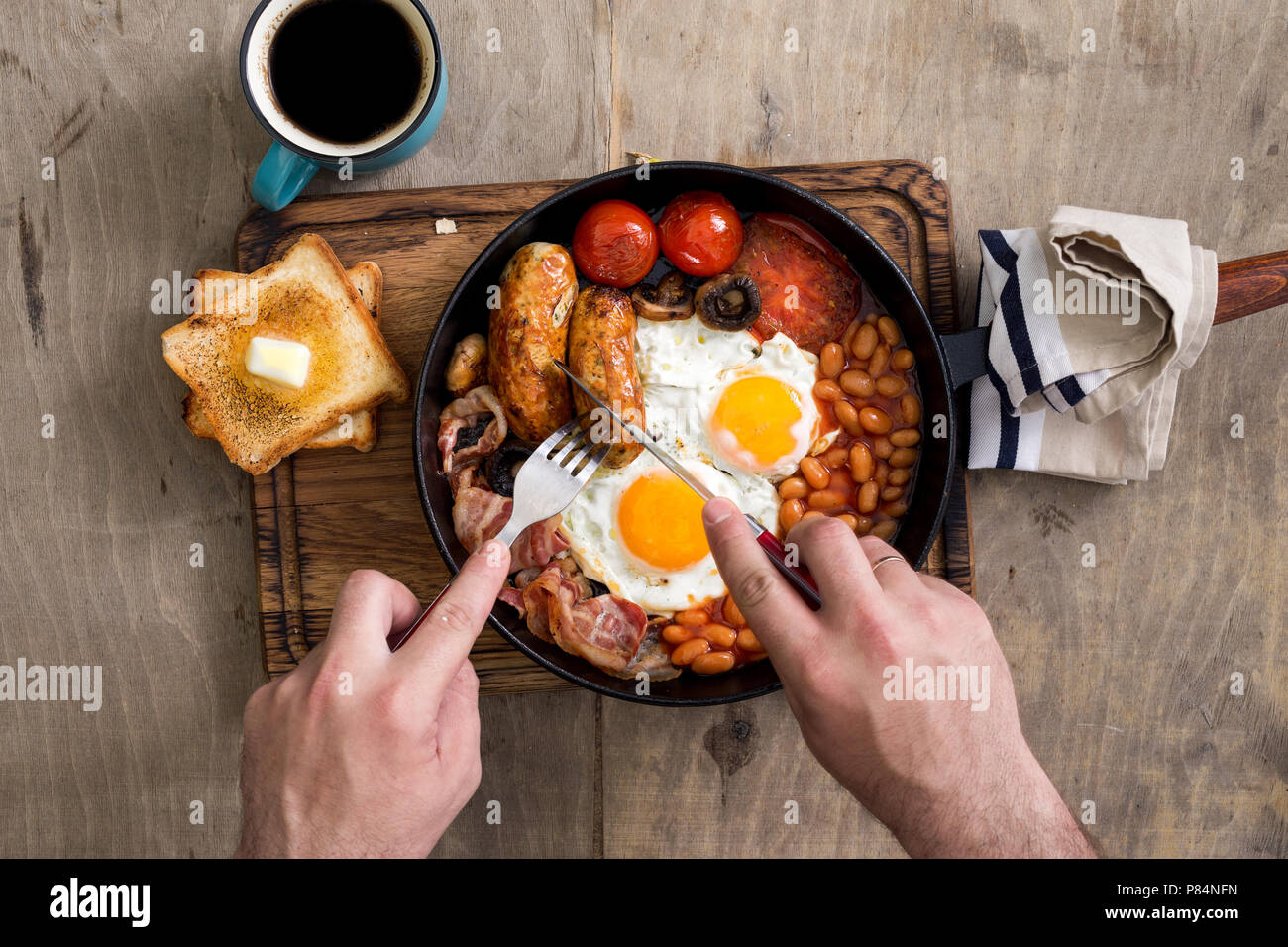 Man is eating English breakfast on a wooden light table, top view Stock ...