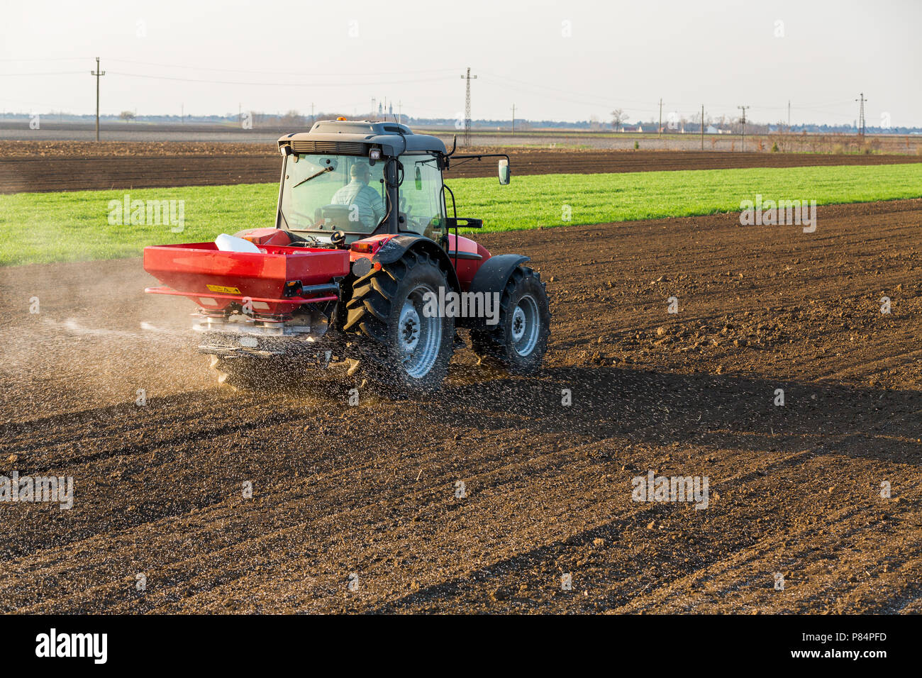 Farmer fertilizing arable land with nitrogen, phosphorus, potassium ...