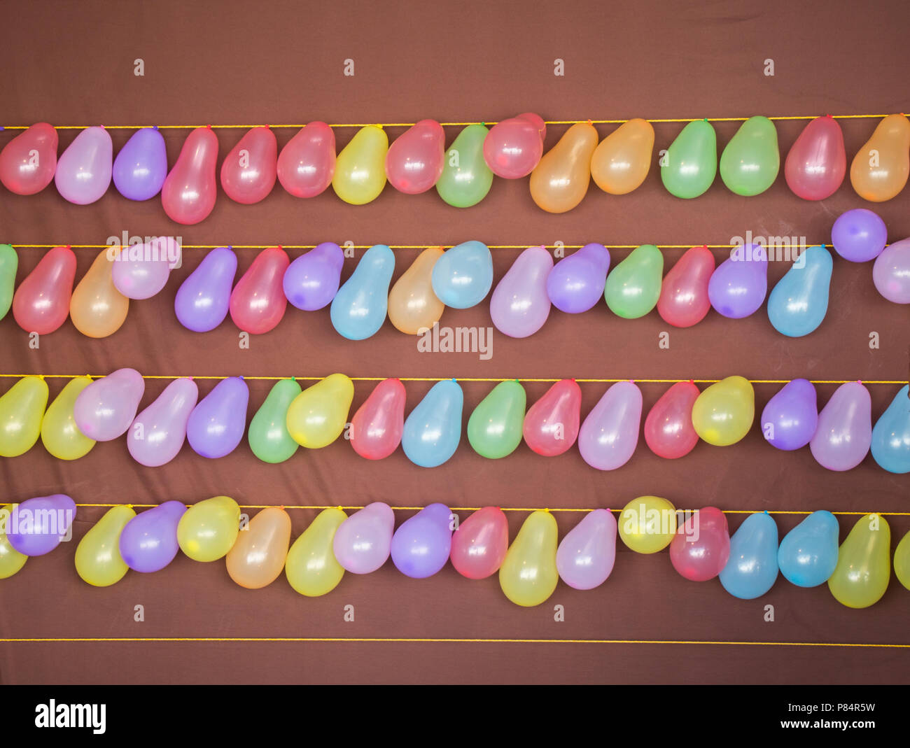 Balloon shooting game with balloons tied on a string Stock Photo - Alamy