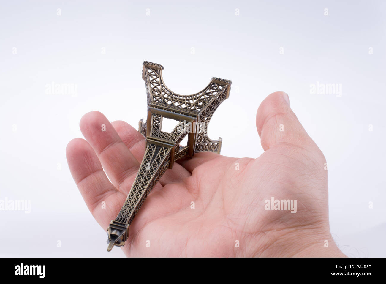 Hand holding the Eiffel tower on a white background Stock Photo - Alamy