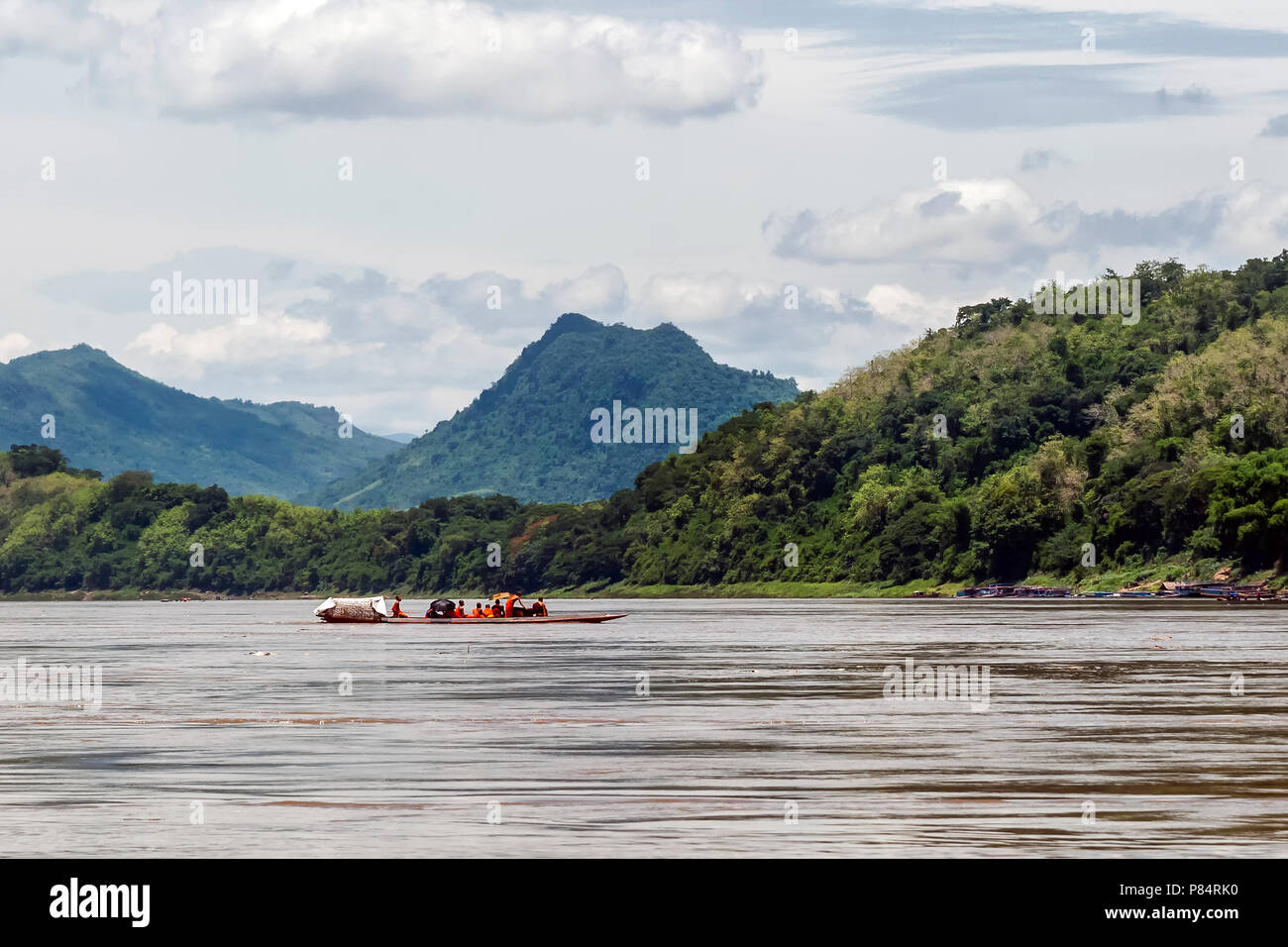 Group of young Buddhist monks navigate the Mekong River with a long ...