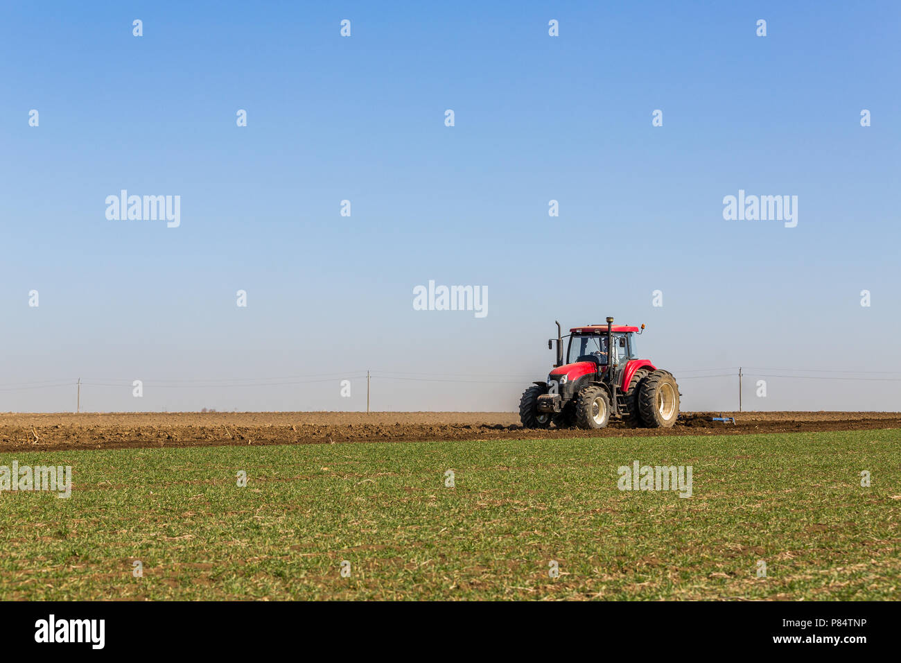 Tractor cultivating field at spring Stock Photo - Alamy