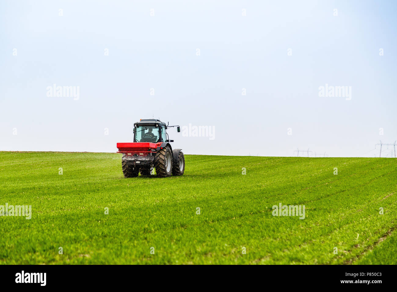 Farmer in tractor fertilizing wheat field at spring with npk Stock ...