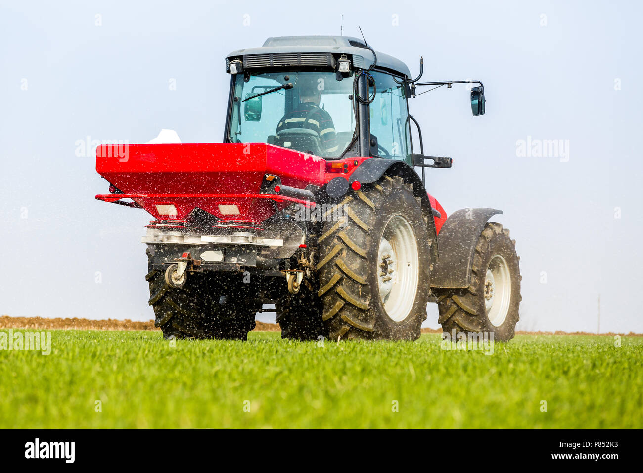 Farmer in tractor fertilizing wheat field at spring with npk Stock ...