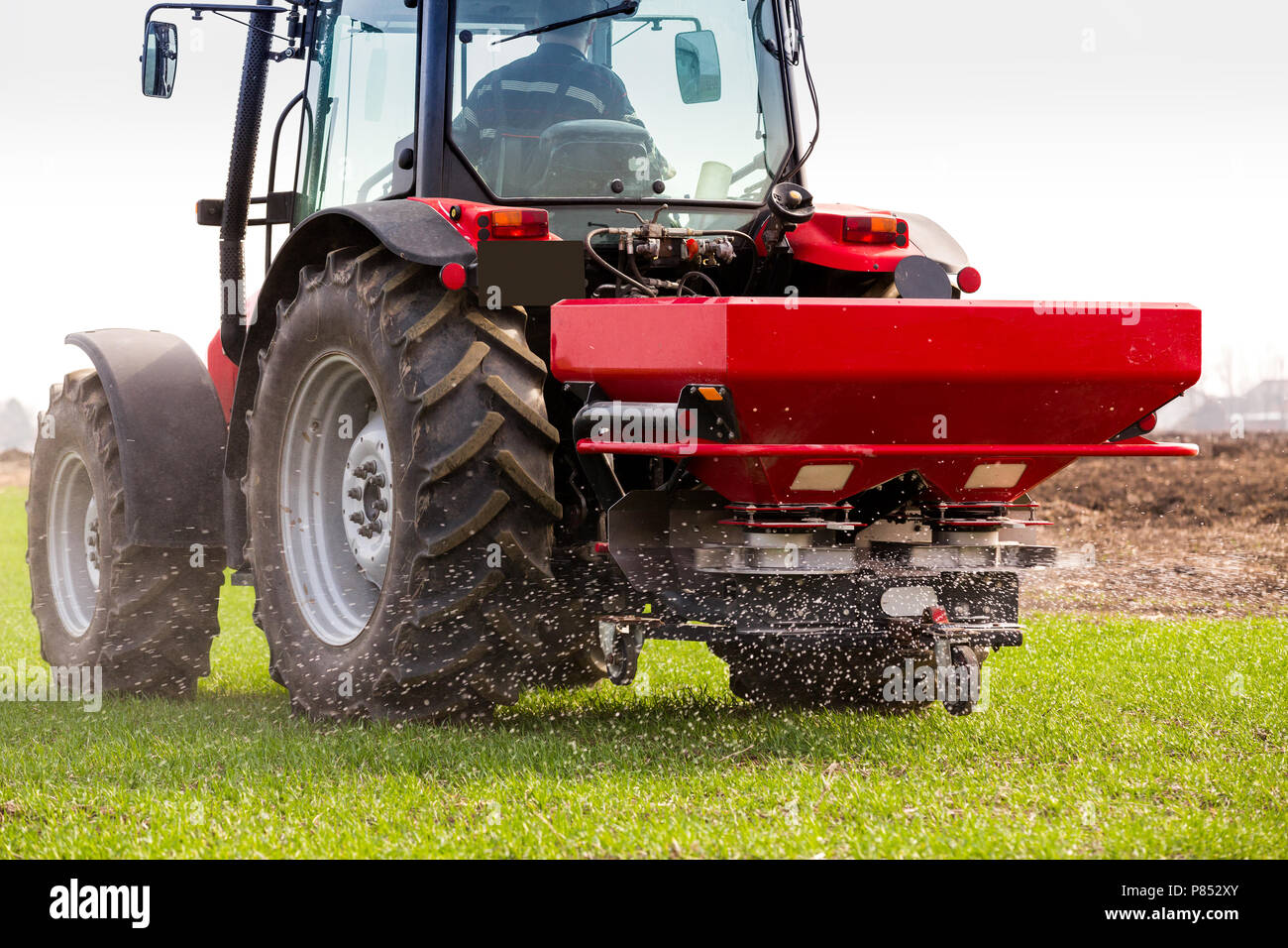 Farmer in tractor fertilizing wheat field at spring with npk Stock ...