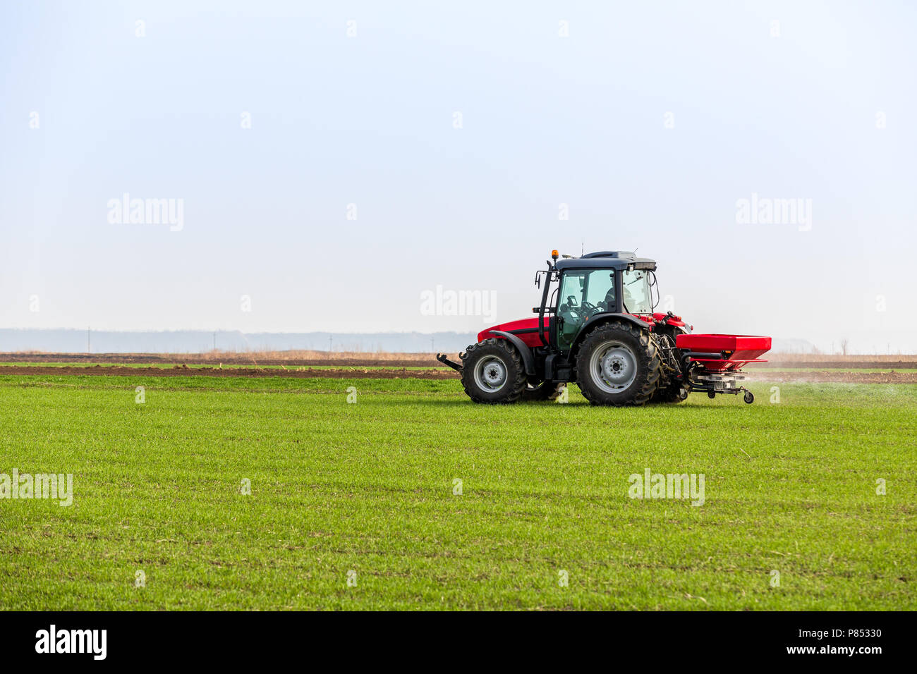 Farmer in tractor fertilizing wheat field at spring with npk Stock ...