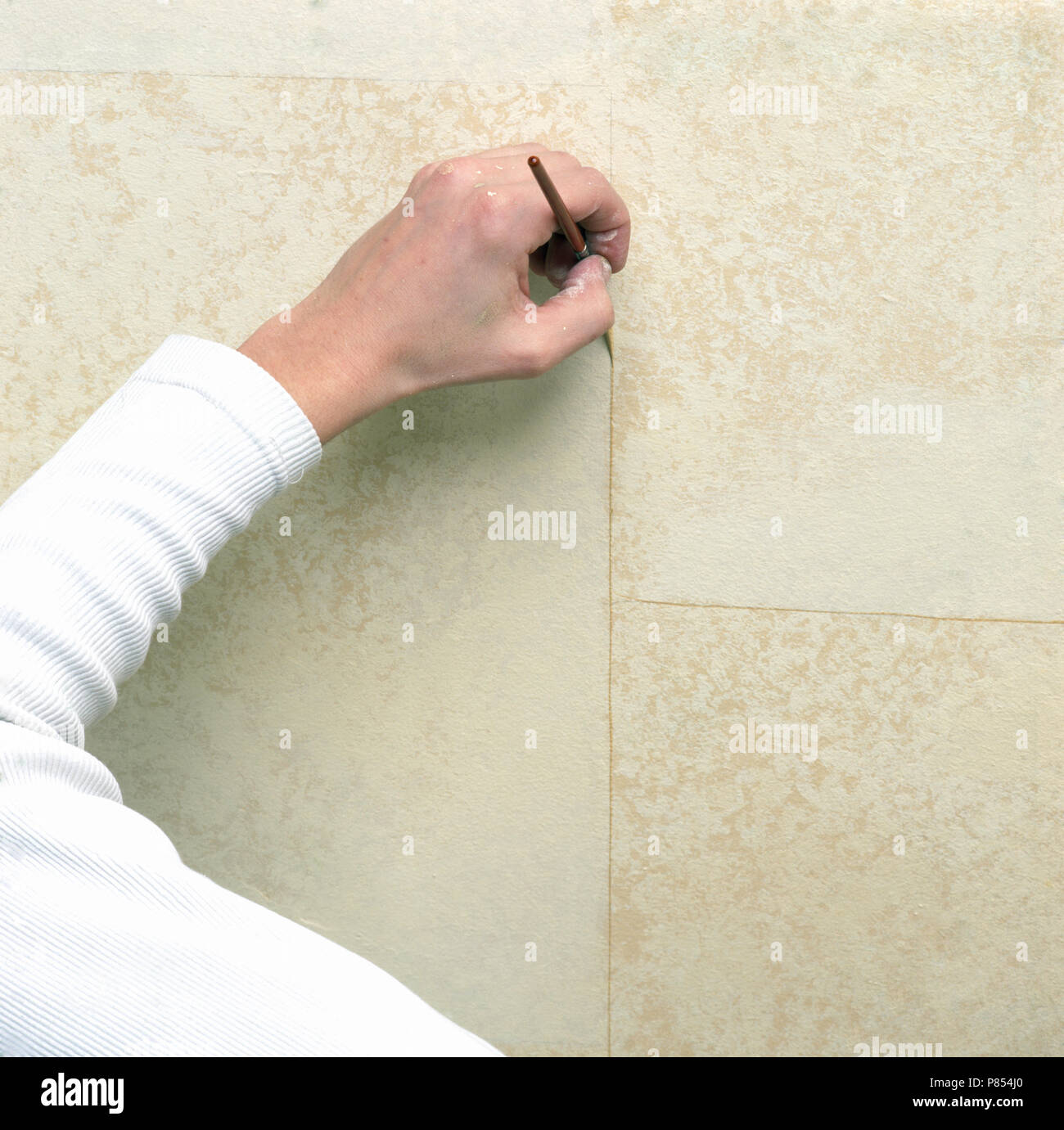 Close-up of a hand marking out a tile pattern on wall Stock Photo - Alamy