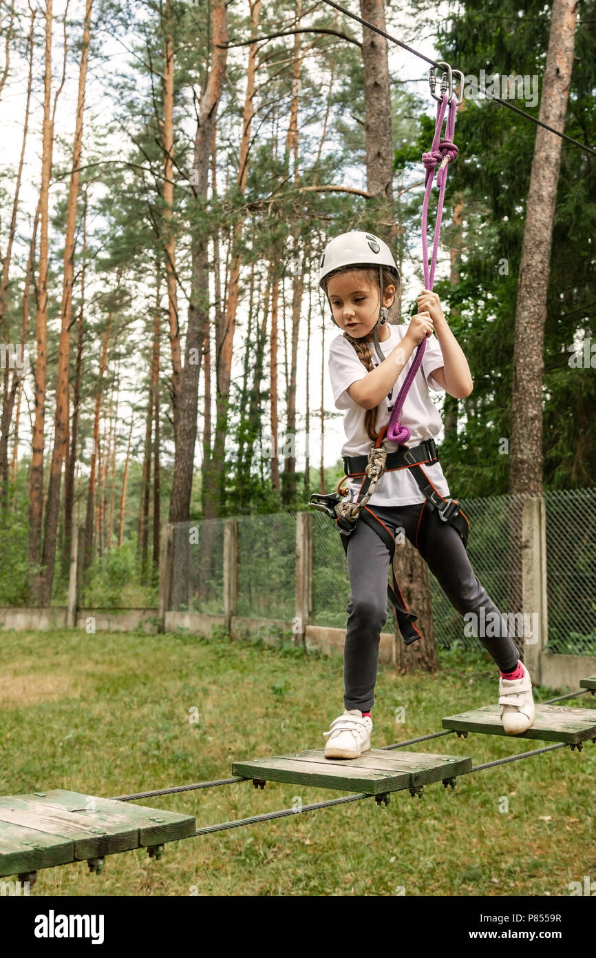 Girl climbing a path in a park rope Stock Photo - Alamy