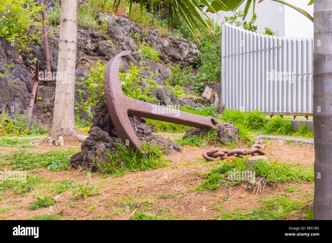 Huge cast iron boat anchor with chain against a block of stone in a ...