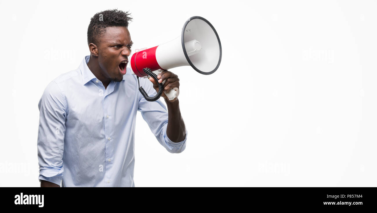 Young african american man holding megaphone annoyed and frustrated ...