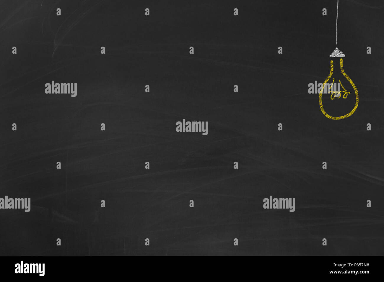 Yellow light bulb painted with chalk on dirty black chalkboard in ...