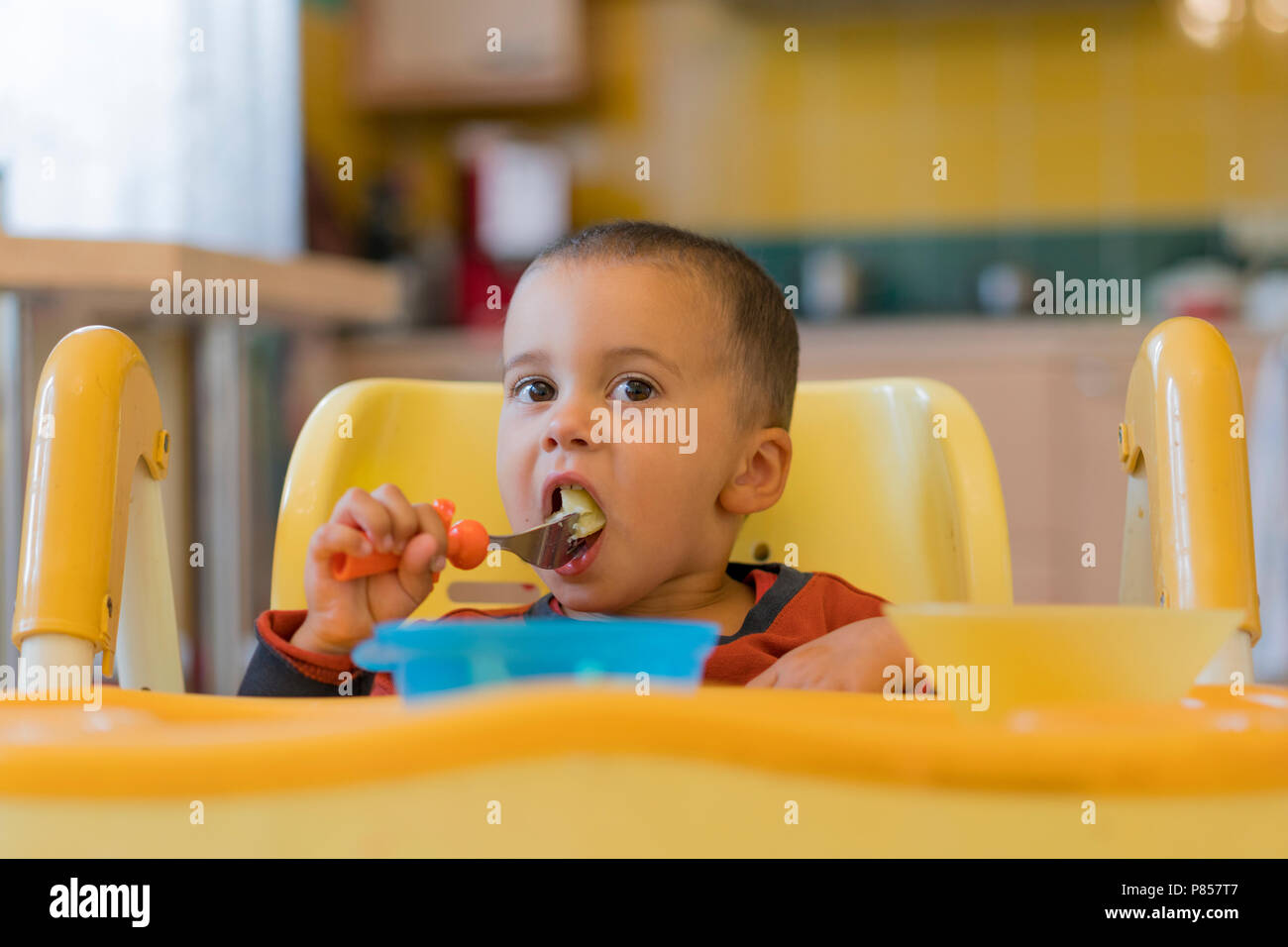 The boy 2 years eating meat. Children's table. The concept of the child ...