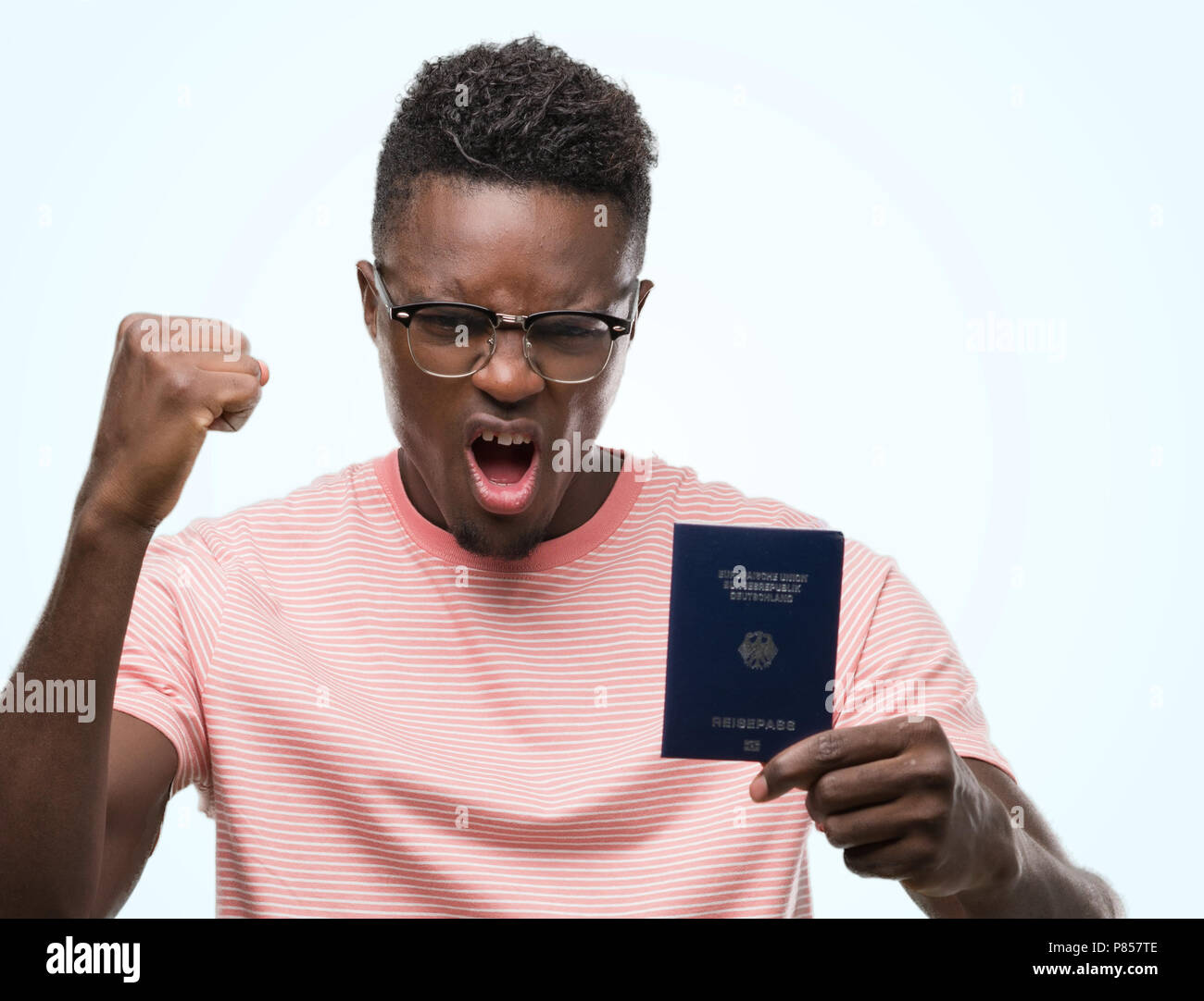Young african american man holding german passport annoyed and ...