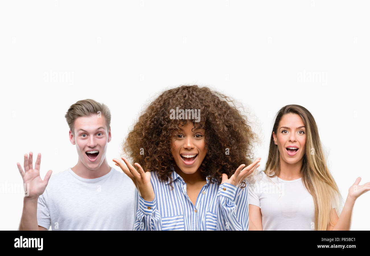 Group of young people over white background very happy and excited ...