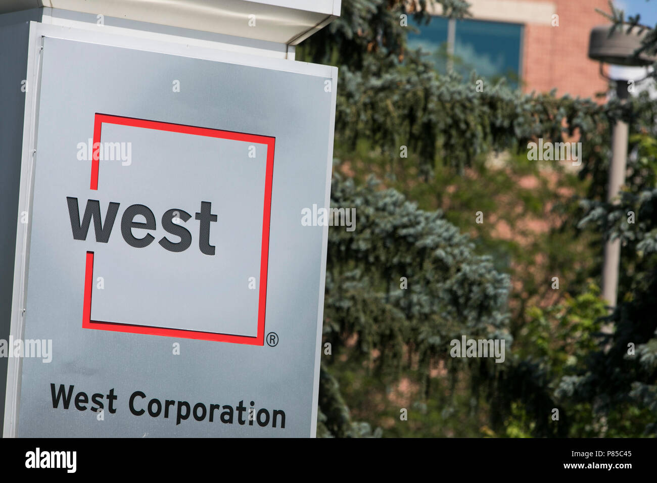 A logo sign outside of the headquarters of the West Corporation in ...