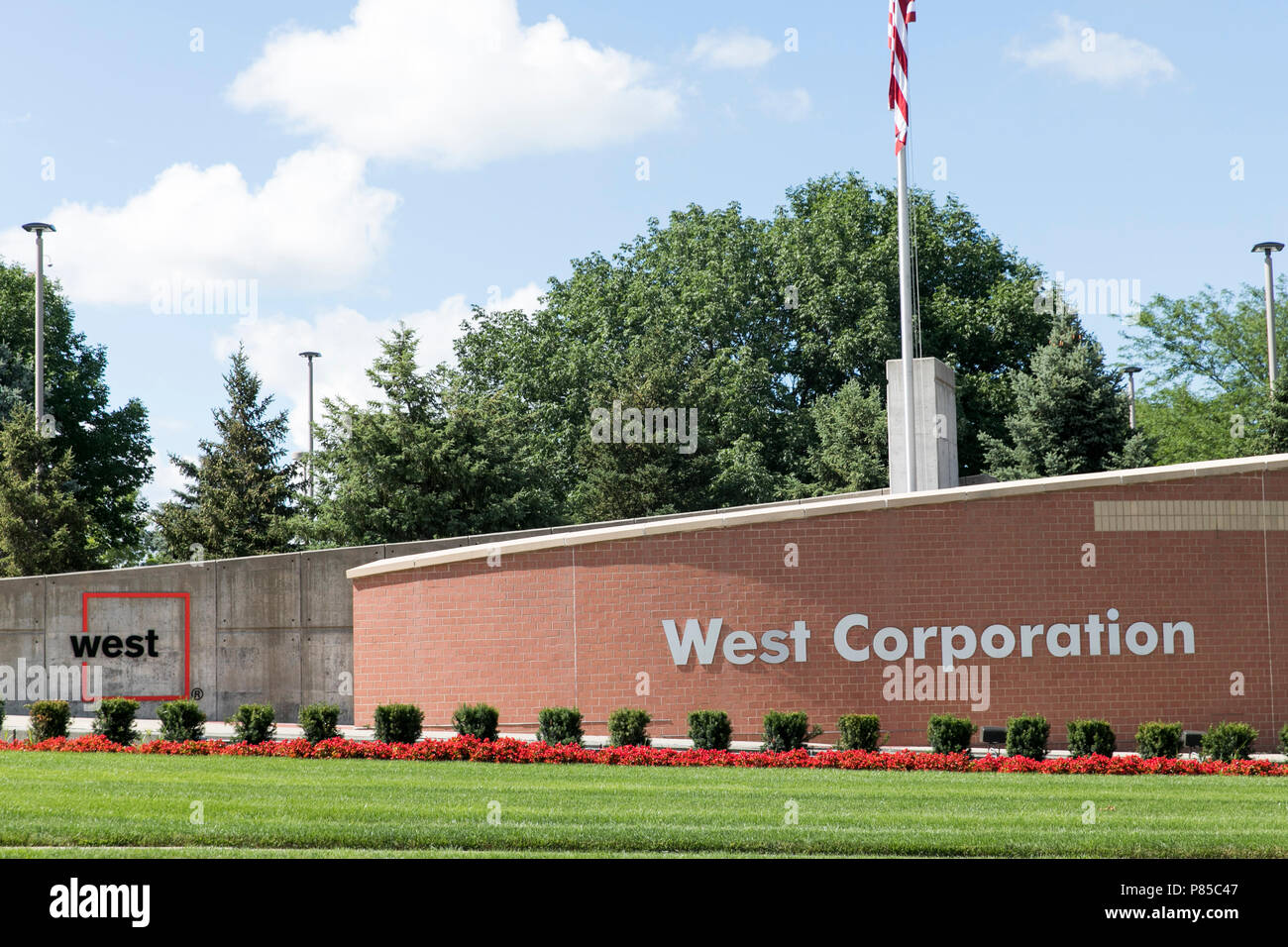 A logo sign outside of the headquarters of the West Corporation in ...