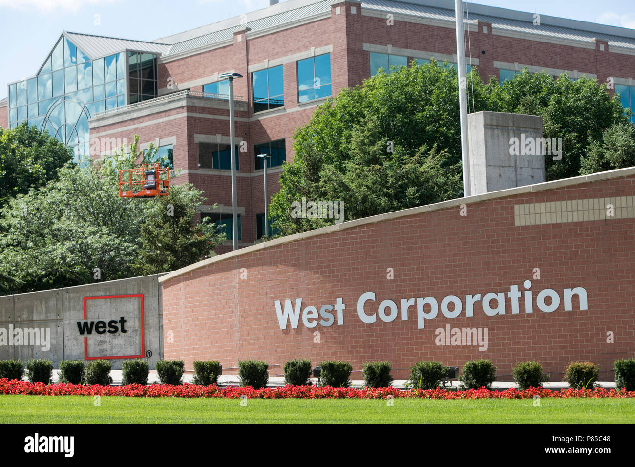 A logo sign outside of the headquarters of the West Corporation in ...