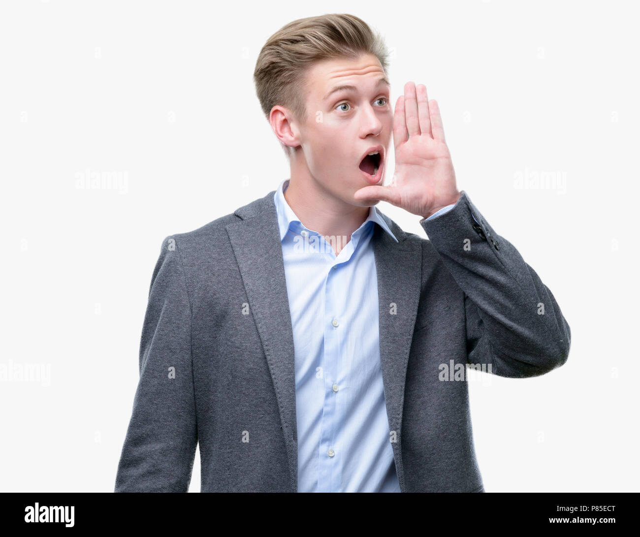 Young handsome blond business man shouting and screaming loud to side ...