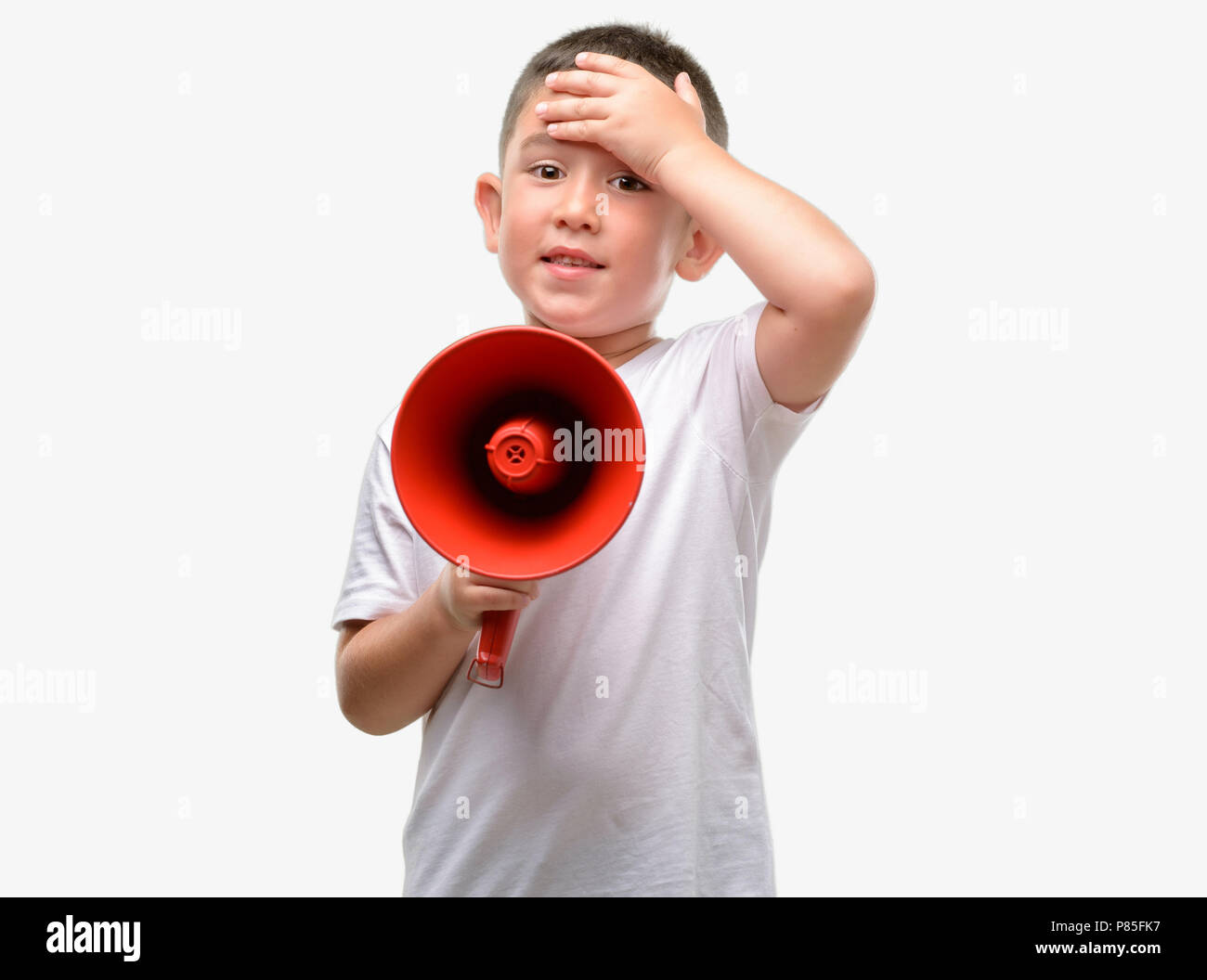 Dark haired little child holding megaphone stressed with hand on head ...