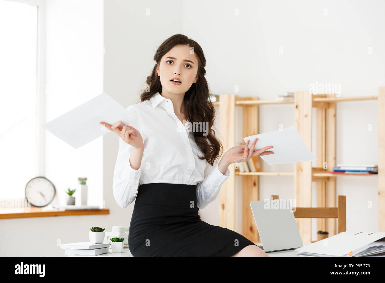 Shocked young business woman surprised by reading unexpected news in ...