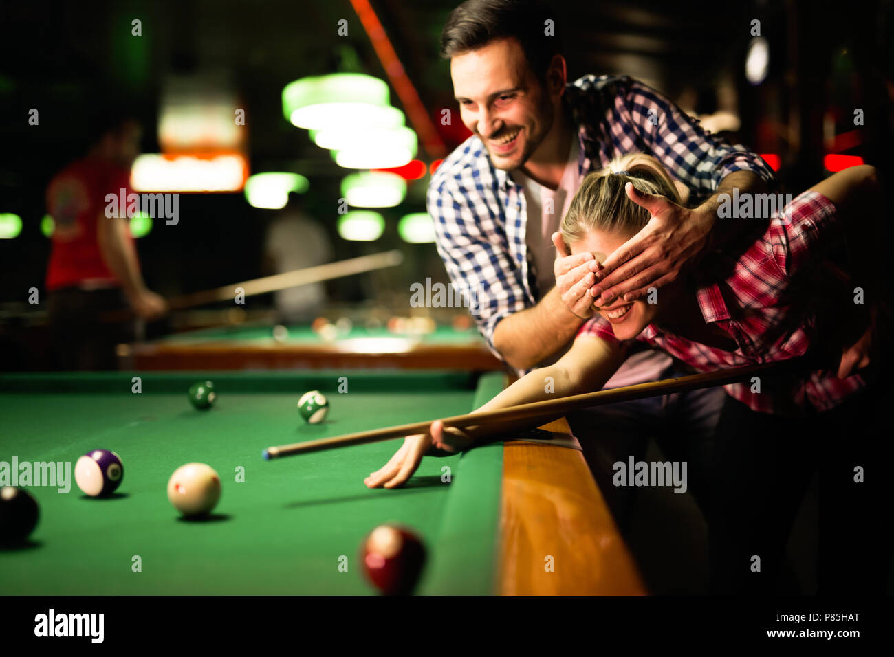 Young couple playing snooker together in bar Stock Photo - Alamy