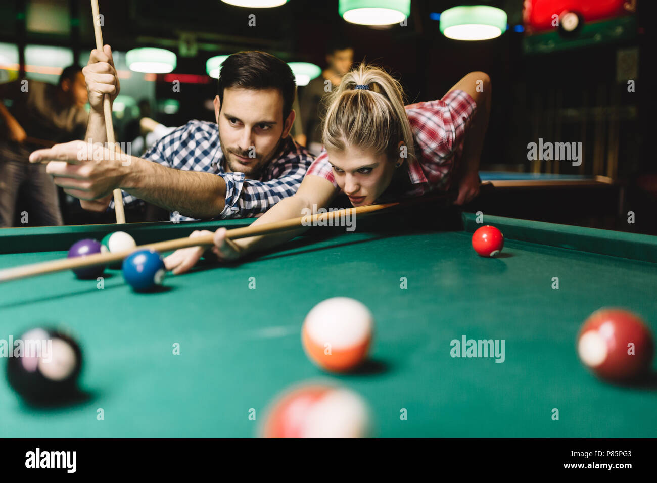Young couple playing snooker together in bar Stock Photo - Alamy