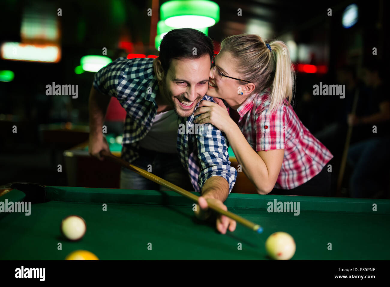 Young couple playing snooker together in bar Stock Photo - Alamy