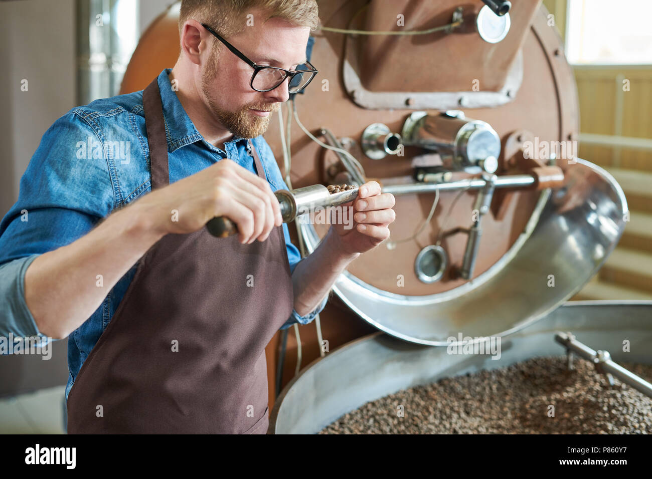 Waist up portrait of modern young man wearing apron and glasses taking ...