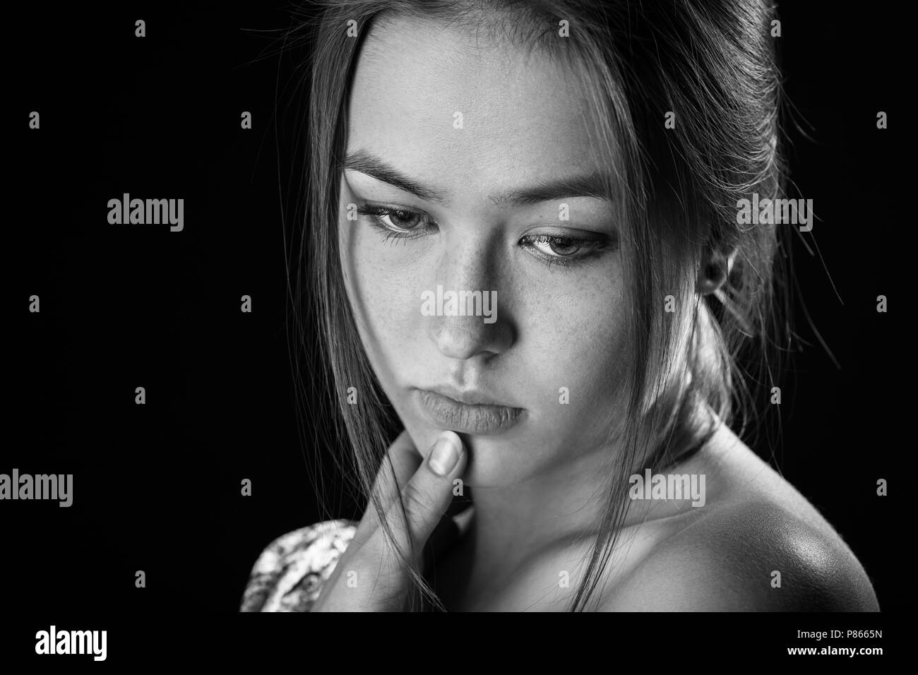 sad pensive young woman thinker on black background, monochrome Stock ...