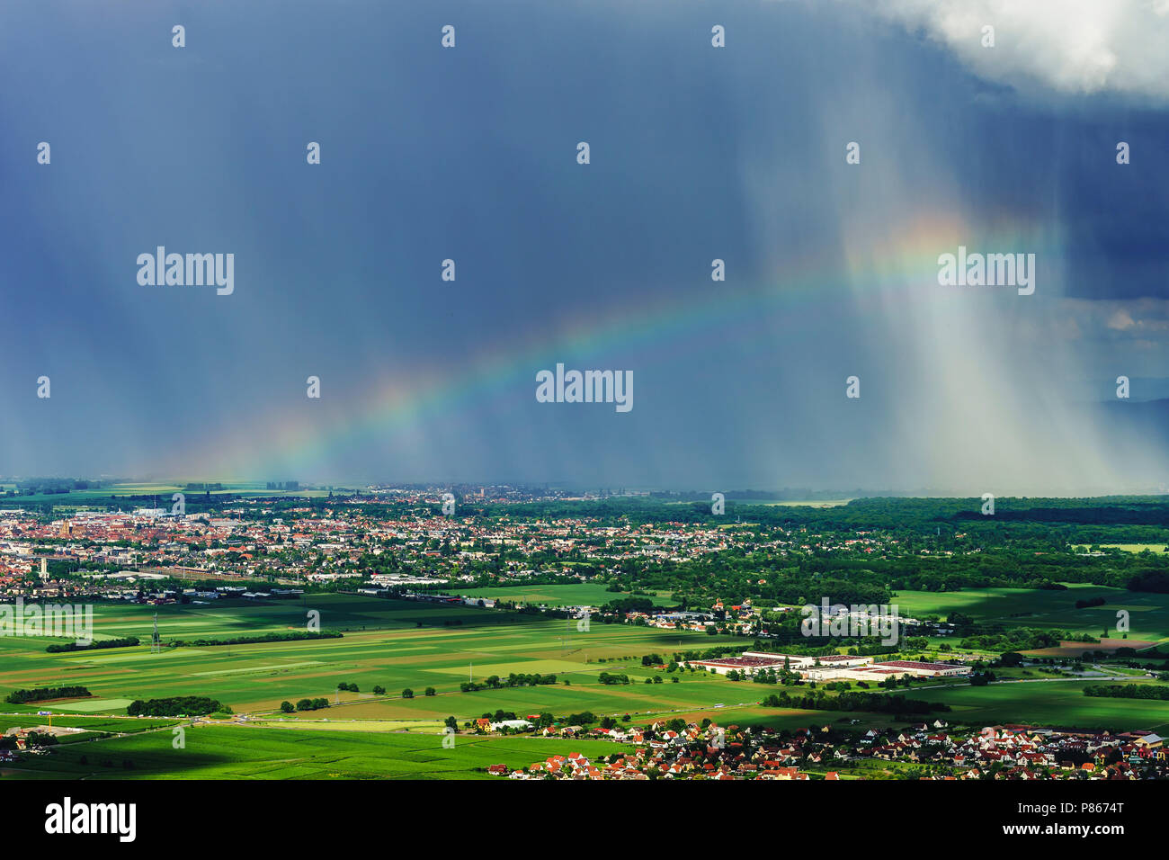 Beautiful rainbow with rainy clouds, colorful summer view, Alsace ...