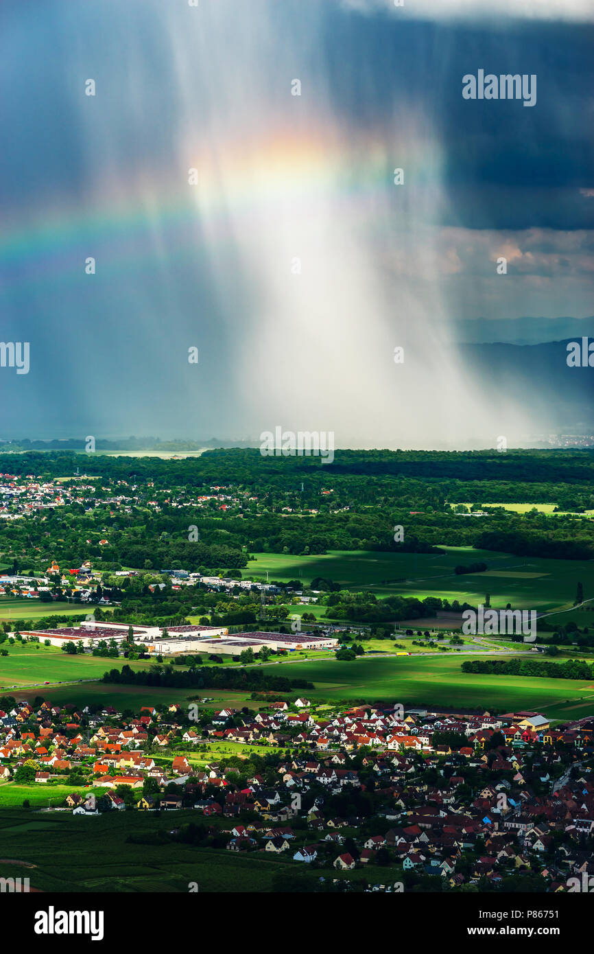 Beautiful rainbow with rainy clouds, colorful summer view, Alsace ...