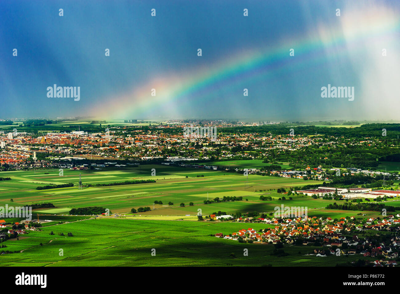 Colorful rainbow over the green fields and vineyards, Alsace, France ...
