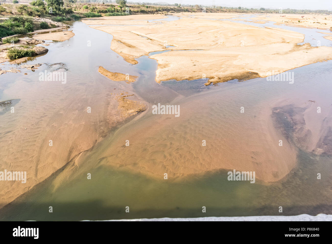 Indian river with clean water in sandy bed with power grid cable laying ...