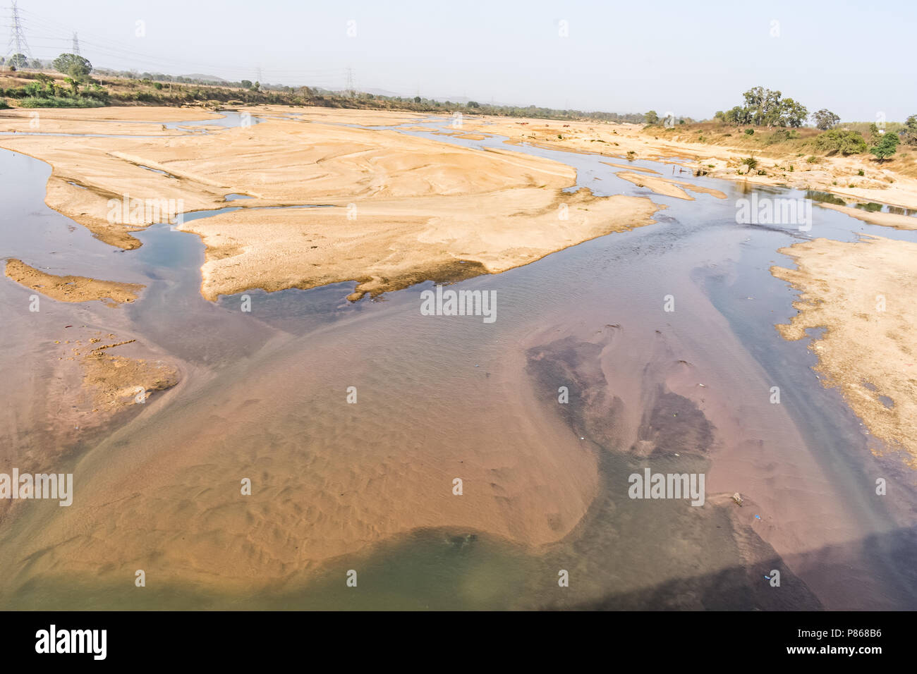 Indian river with clean water in sandy bed with power grid cable laying ...