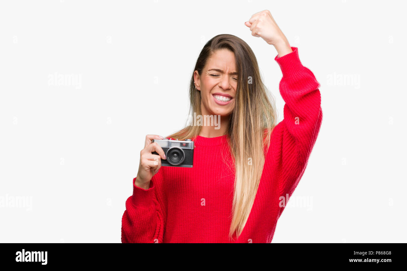 Beautiful young woman holding vintage camera annoyed and frustrated ...