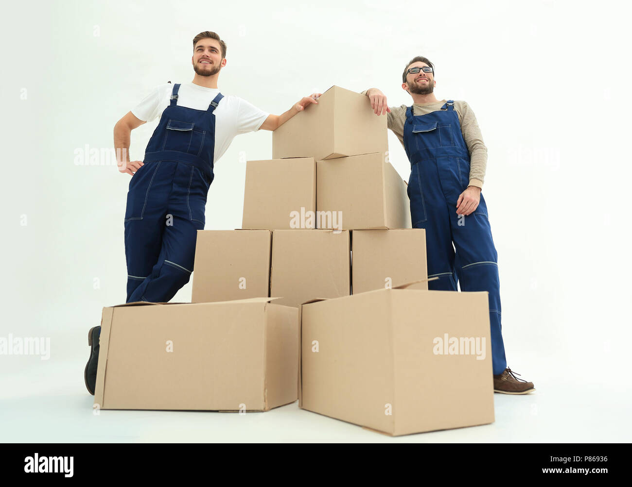 Young men carrying a box to the pile of boxes Stock Photo - Alamy