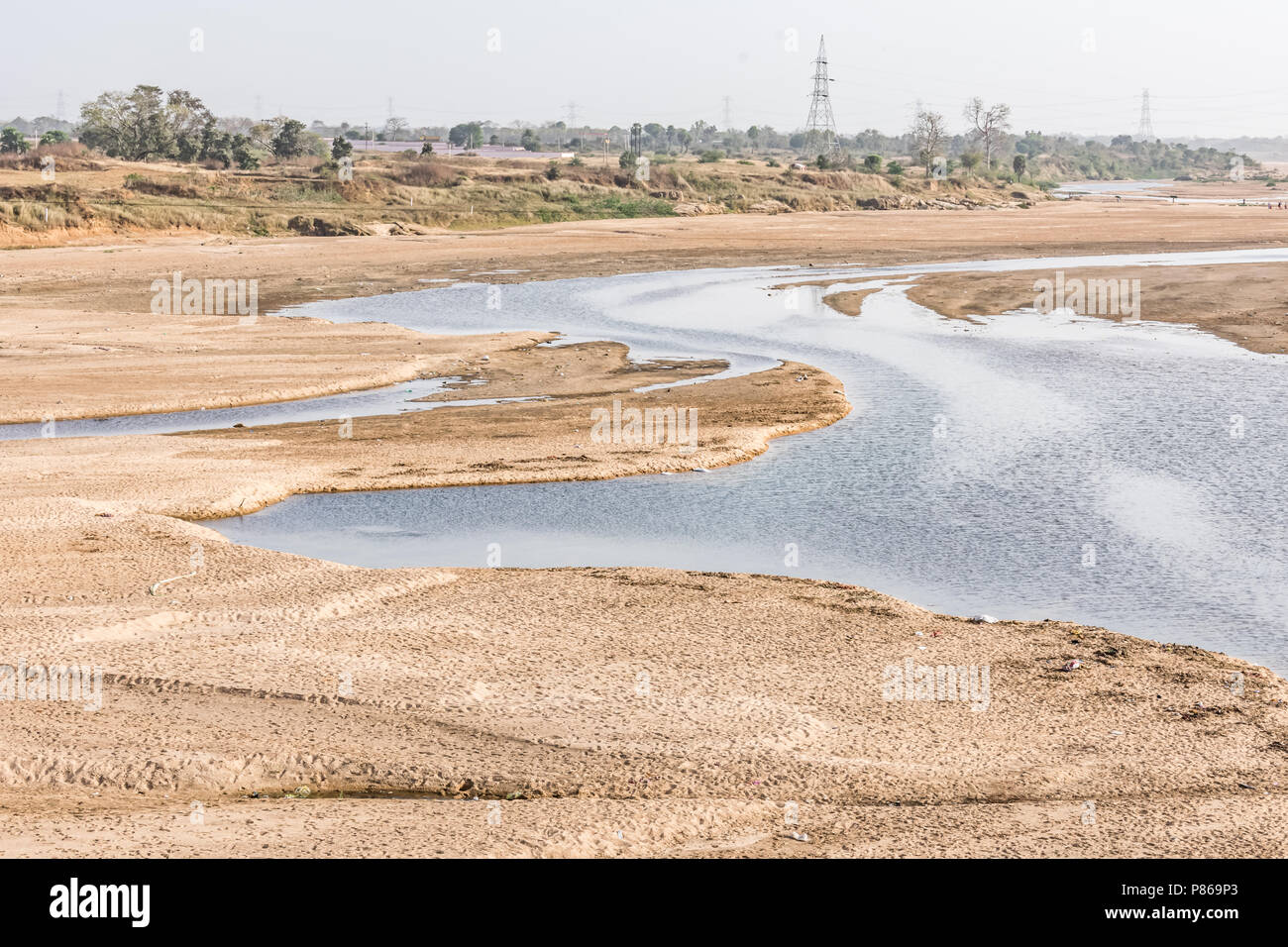 Indian river with clean water in sandy bed with power grid cable laying ...