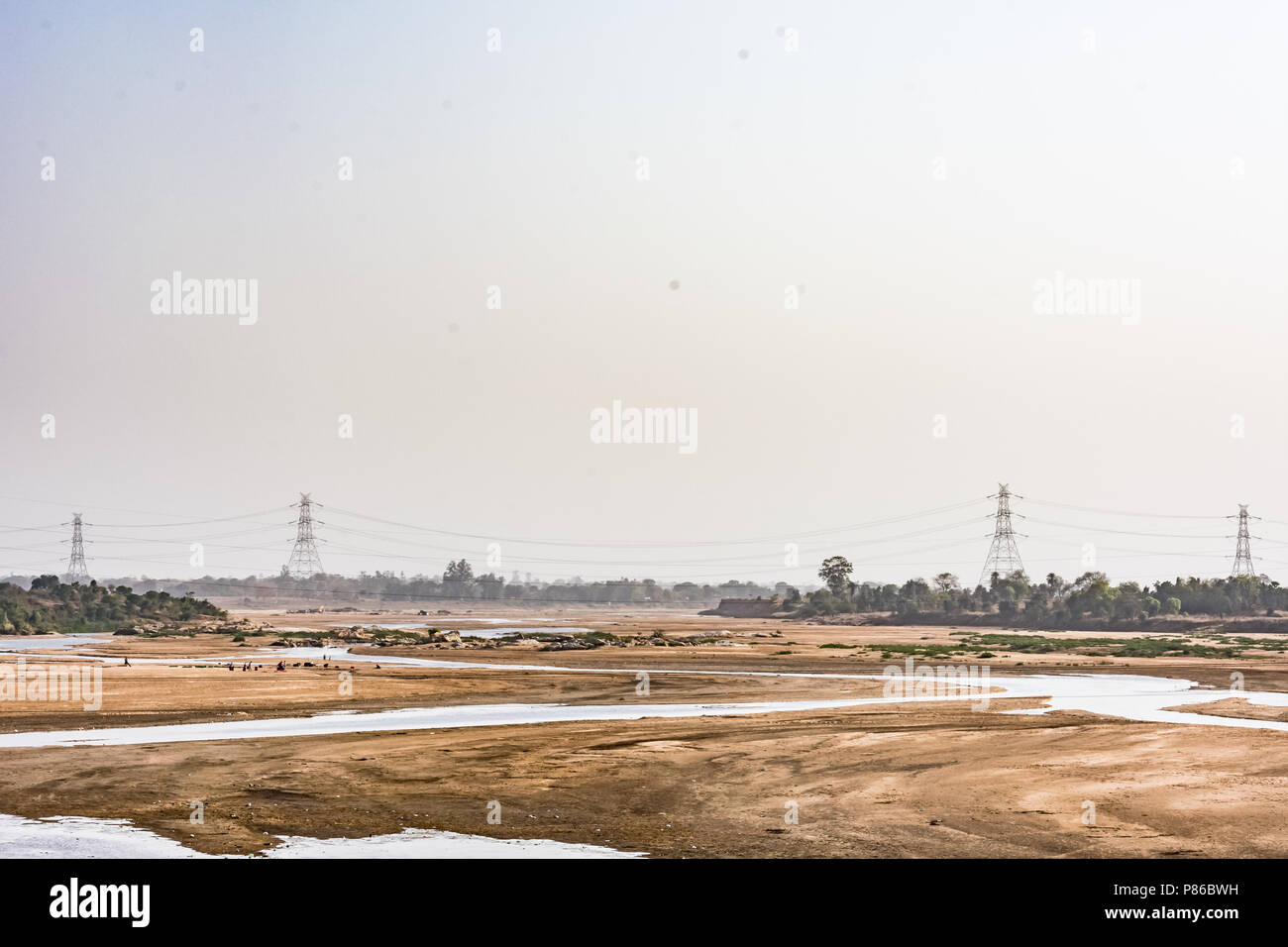 Indian river with clean water in sandy bed with power grid cable laying ...