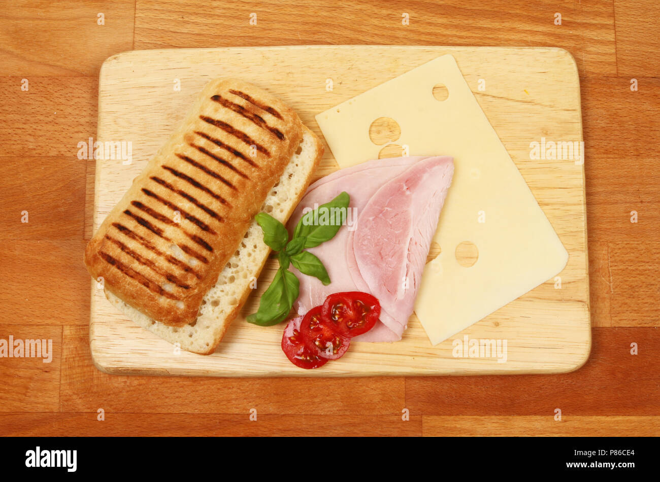 Panini ingredients on a wooden chopping board on a kitchen worktop, top ...