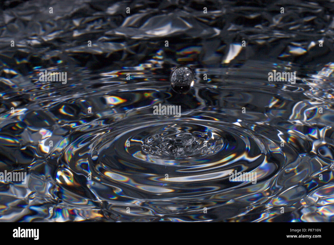 Water droplets falling into water causing splashes and ripples Stock ...