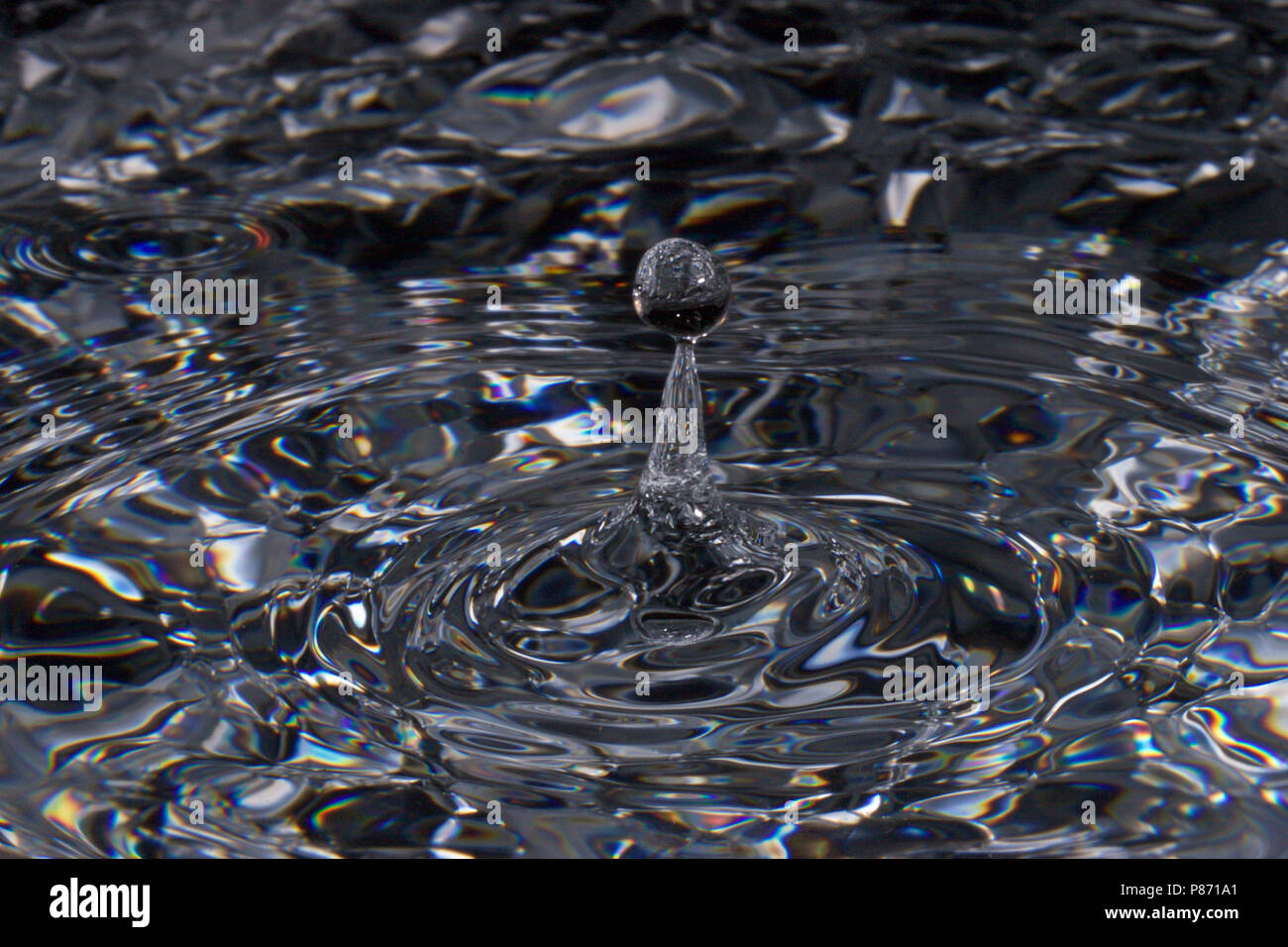 Water droplets falling into water causing splashes and ripples Stock ...