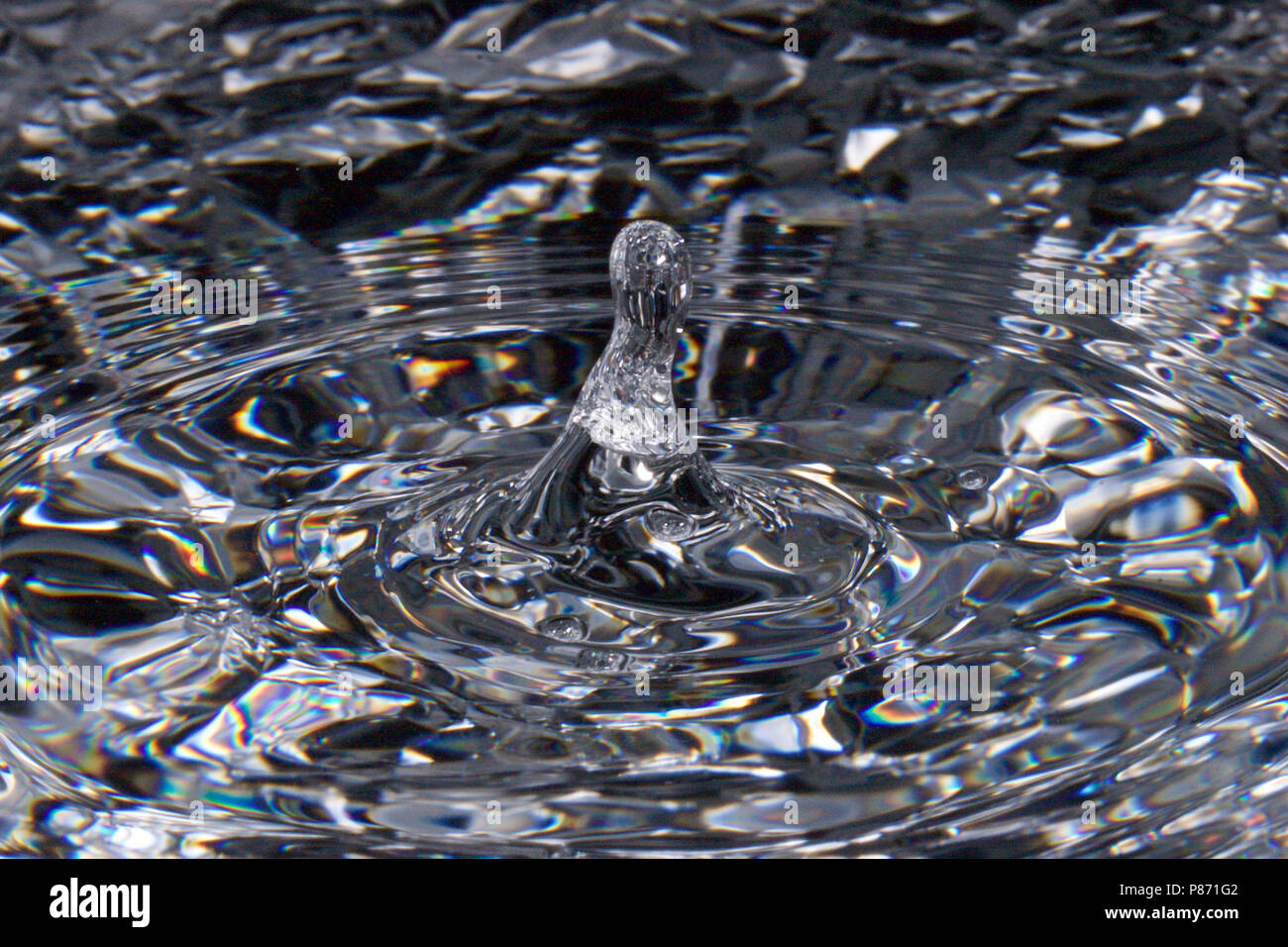 Water droplets falling into water causing splashes and ripples Stock ...
