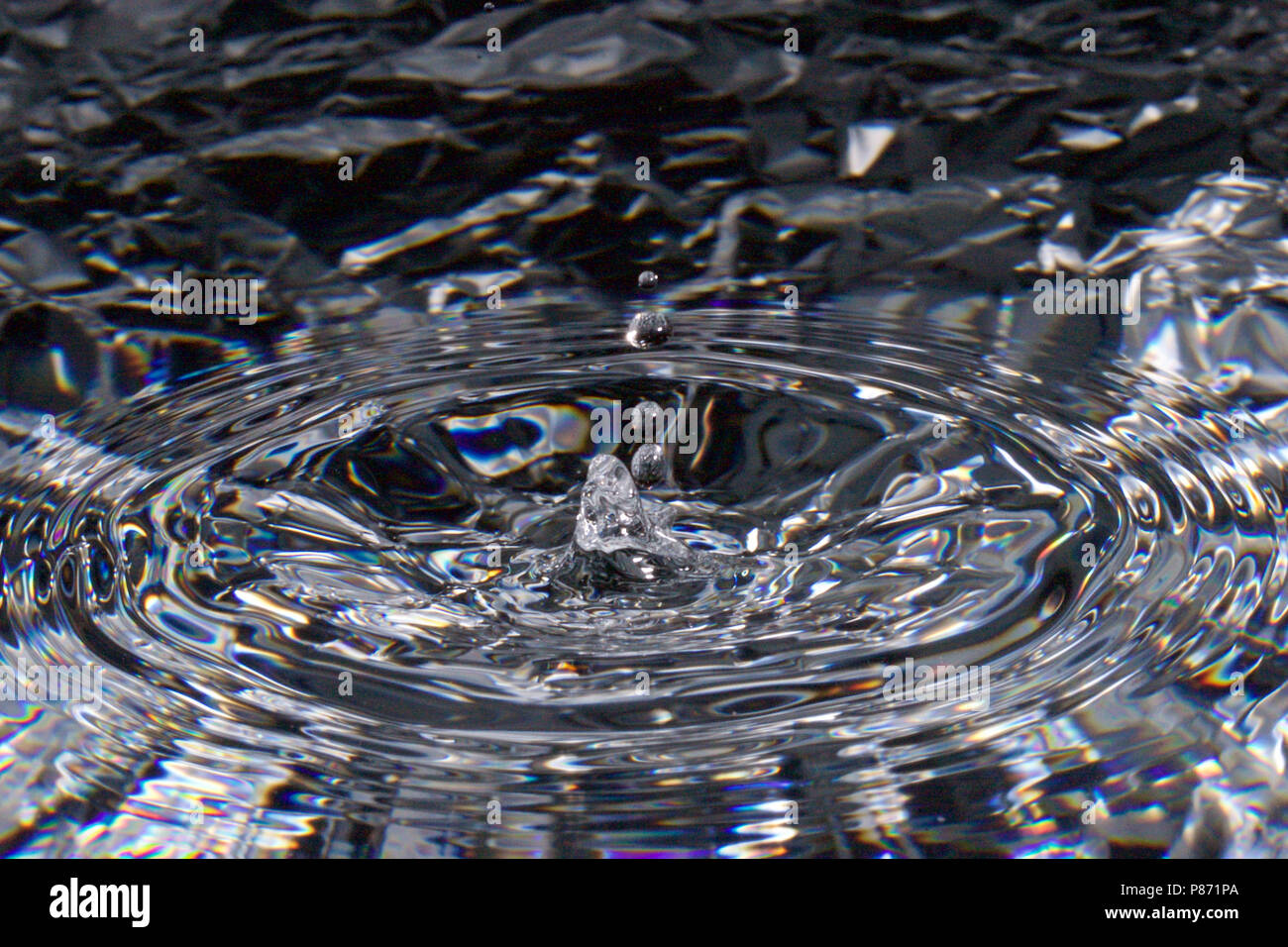 Water droplets falling into water causing splashes and ripples Stock ...