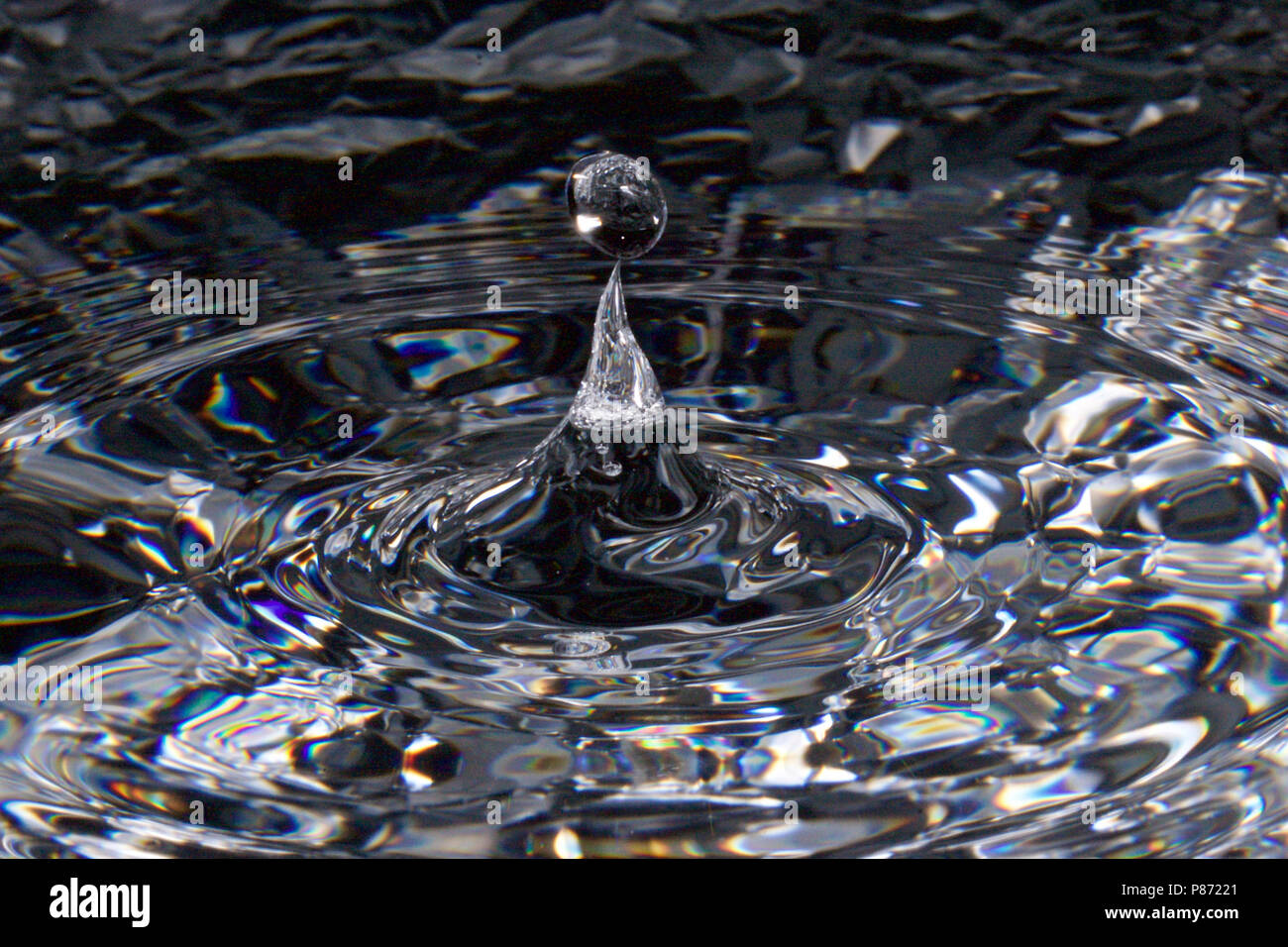 Water droplets falling into water causing splashes and ripples Stock ...