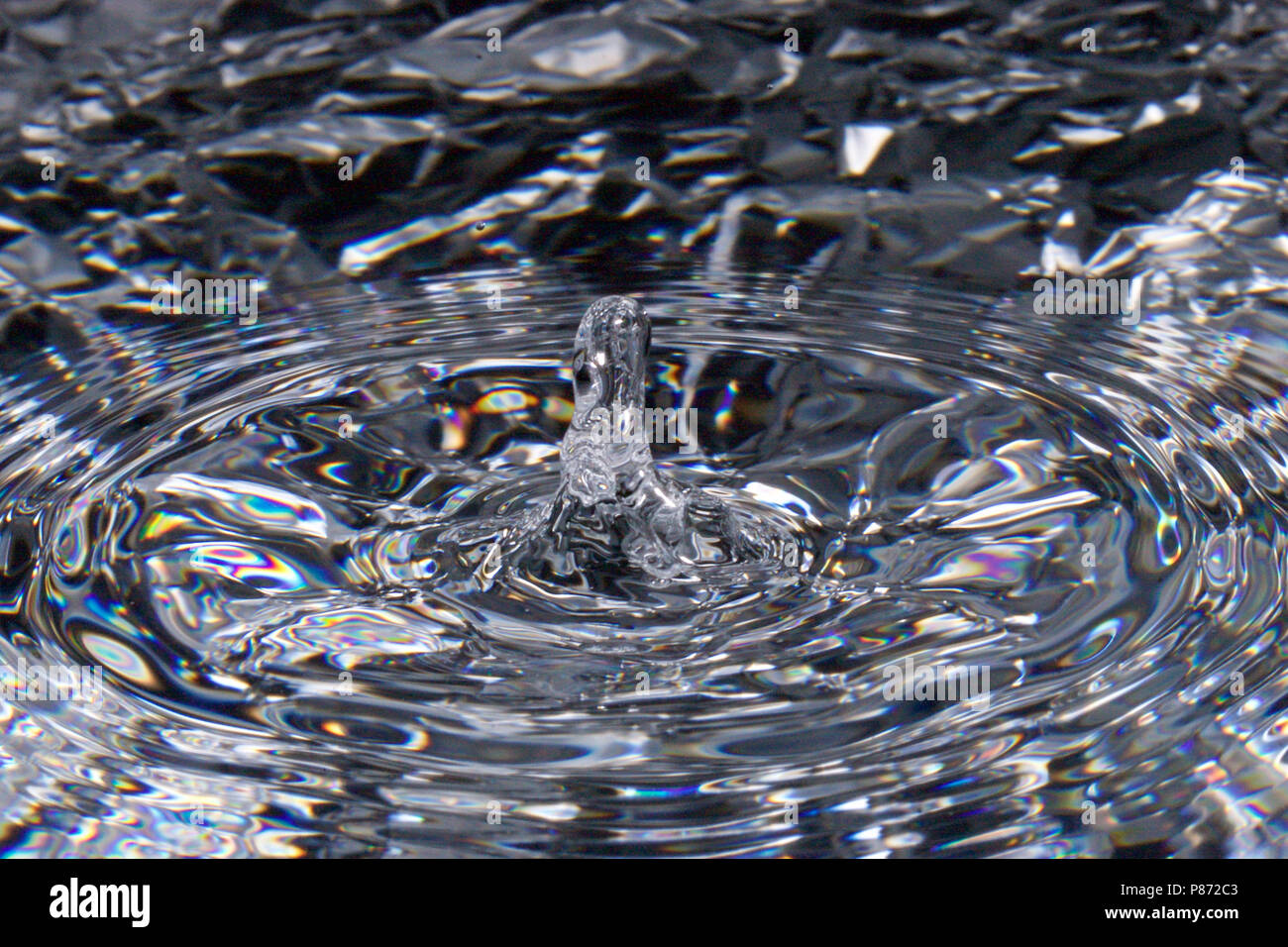 Water droplets falling into water causing splashes and ripples Stock ...