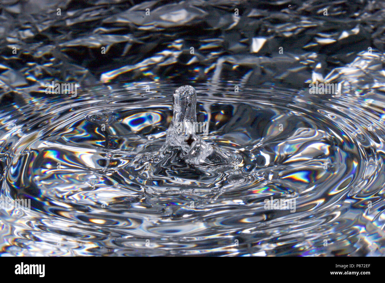 Water droplets falling into water causing splashes and ripples Stock ...