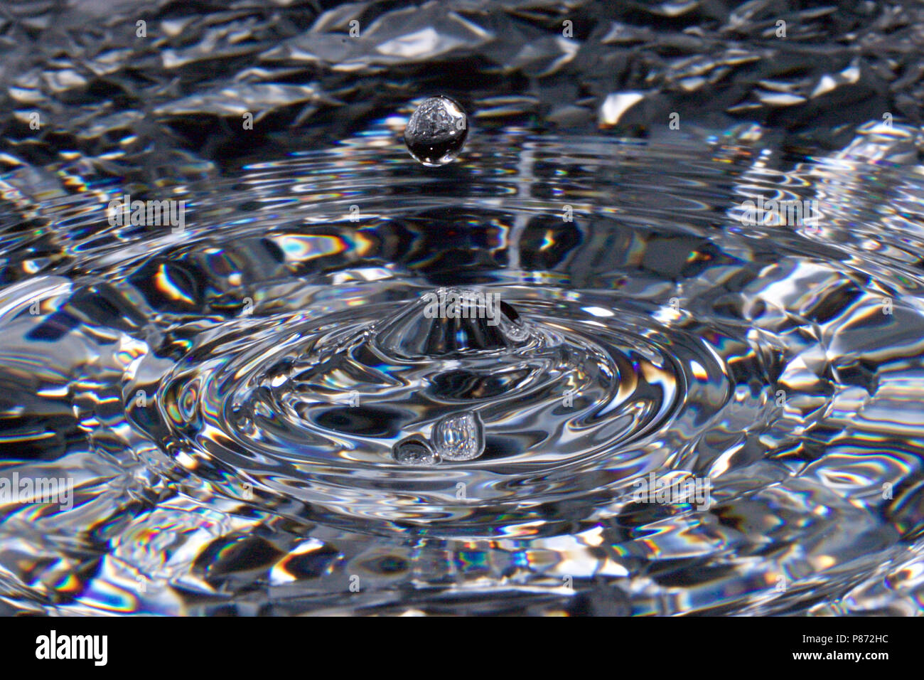 Water droplets falling into water causing splashes and ripples Stock ...